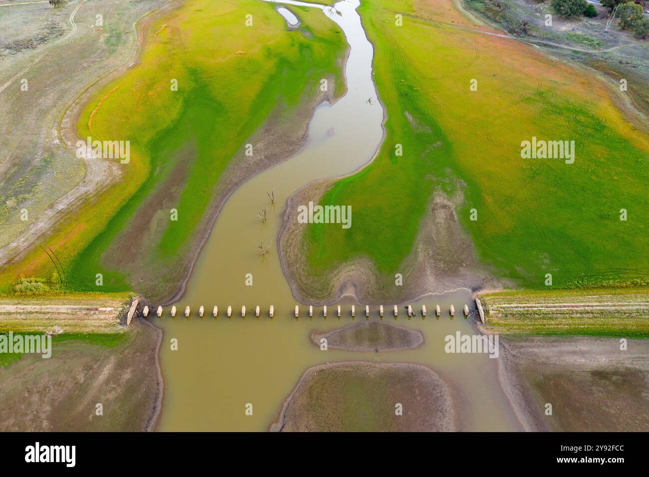 Aerial view of a row of stone bridge pillars running through a drying ...
