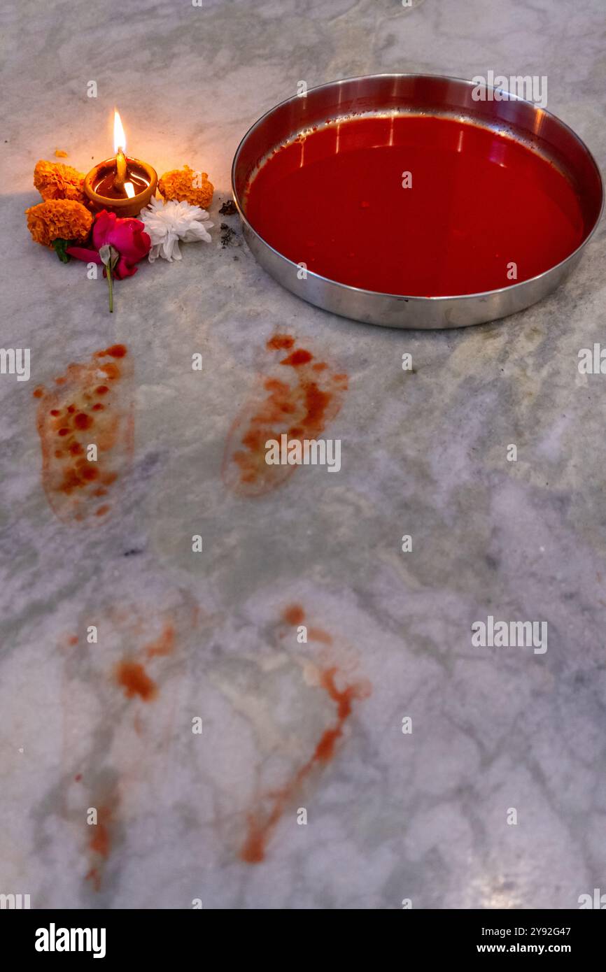 A burning mud lamp (diya) surrounded by vibrant flowers during Navratri ...