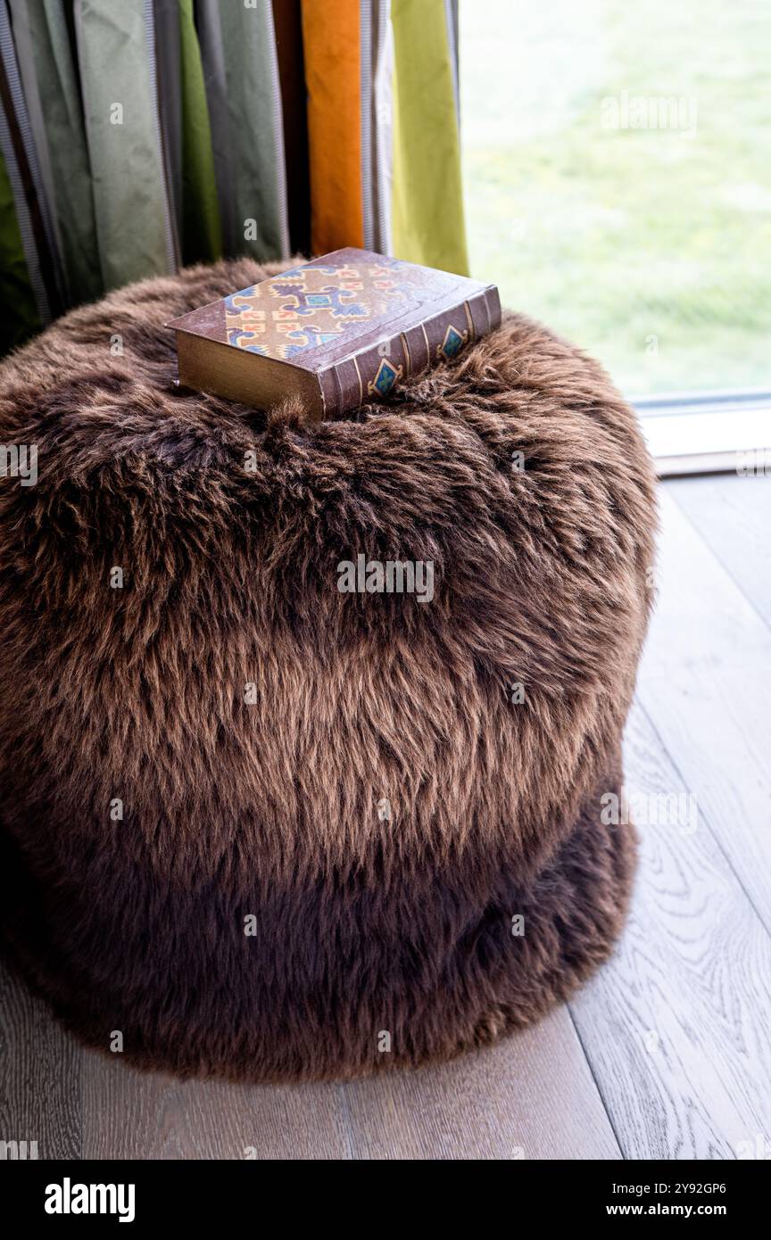 Leather bound book on brown sheepskin pouf by Wildash, sustainably ...