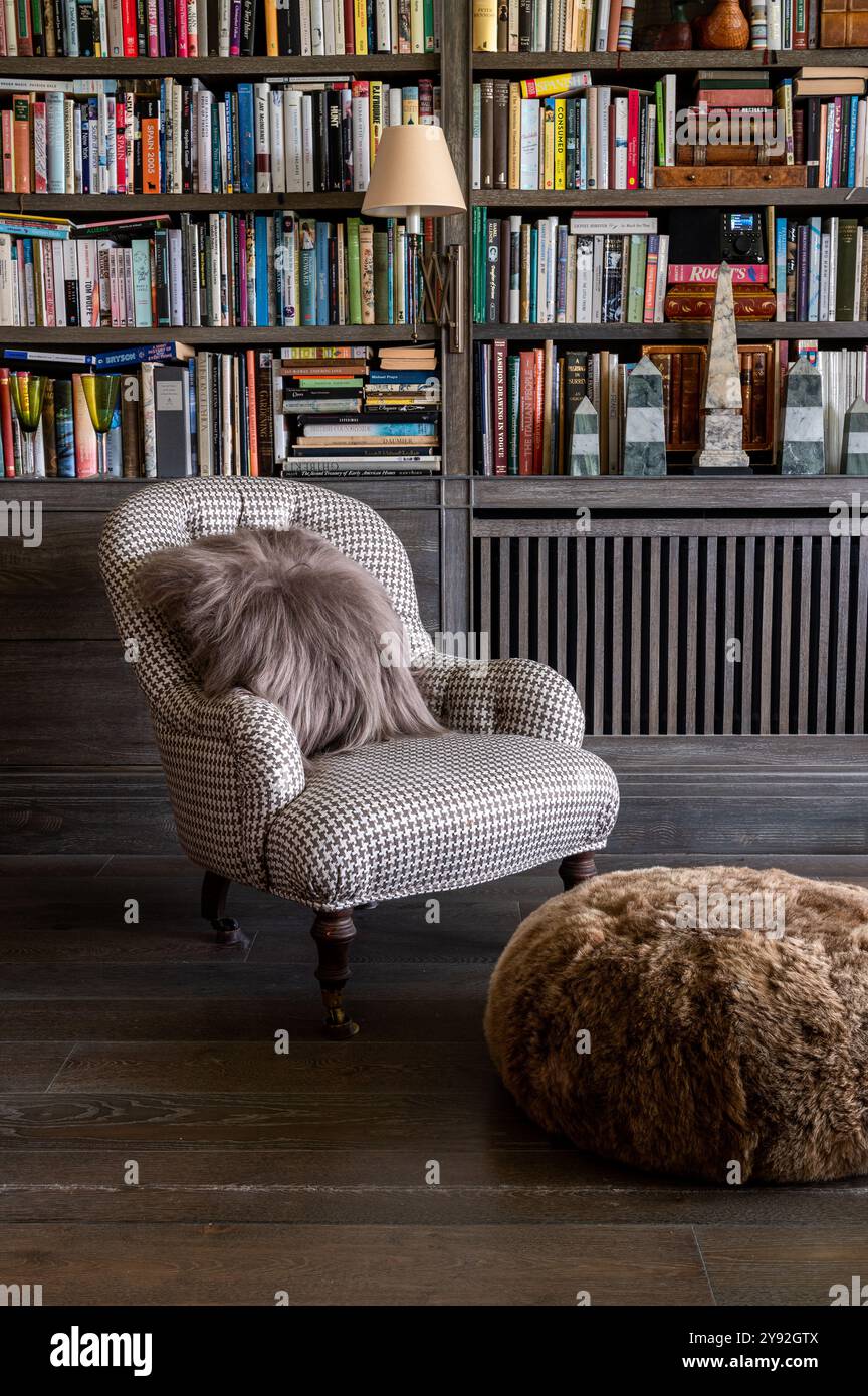 Armchair in library with sheepskin cushion and pouf by Wildash ...