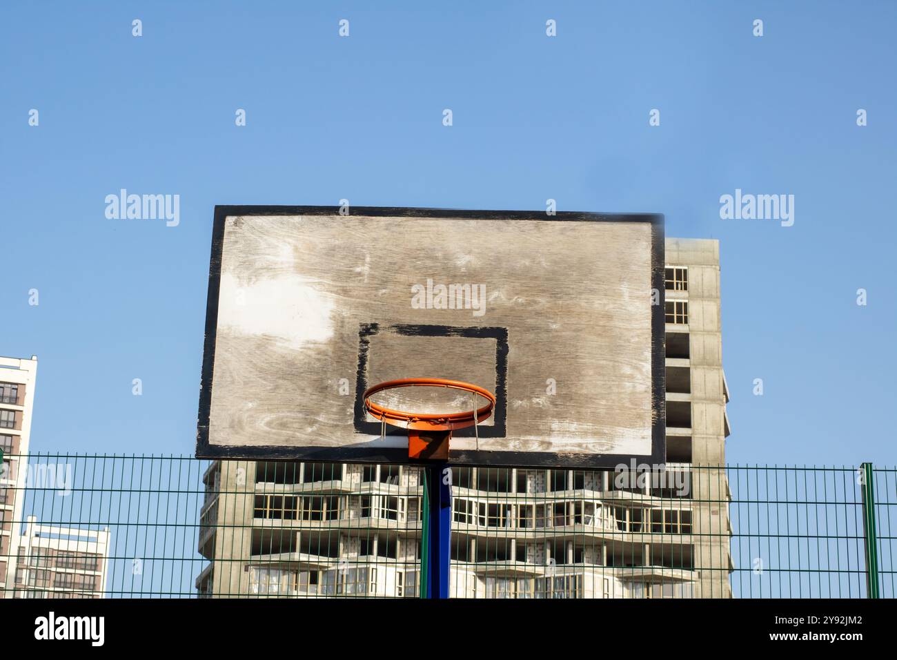 In front of a tall and impressive building, there is a basketball hoop ...