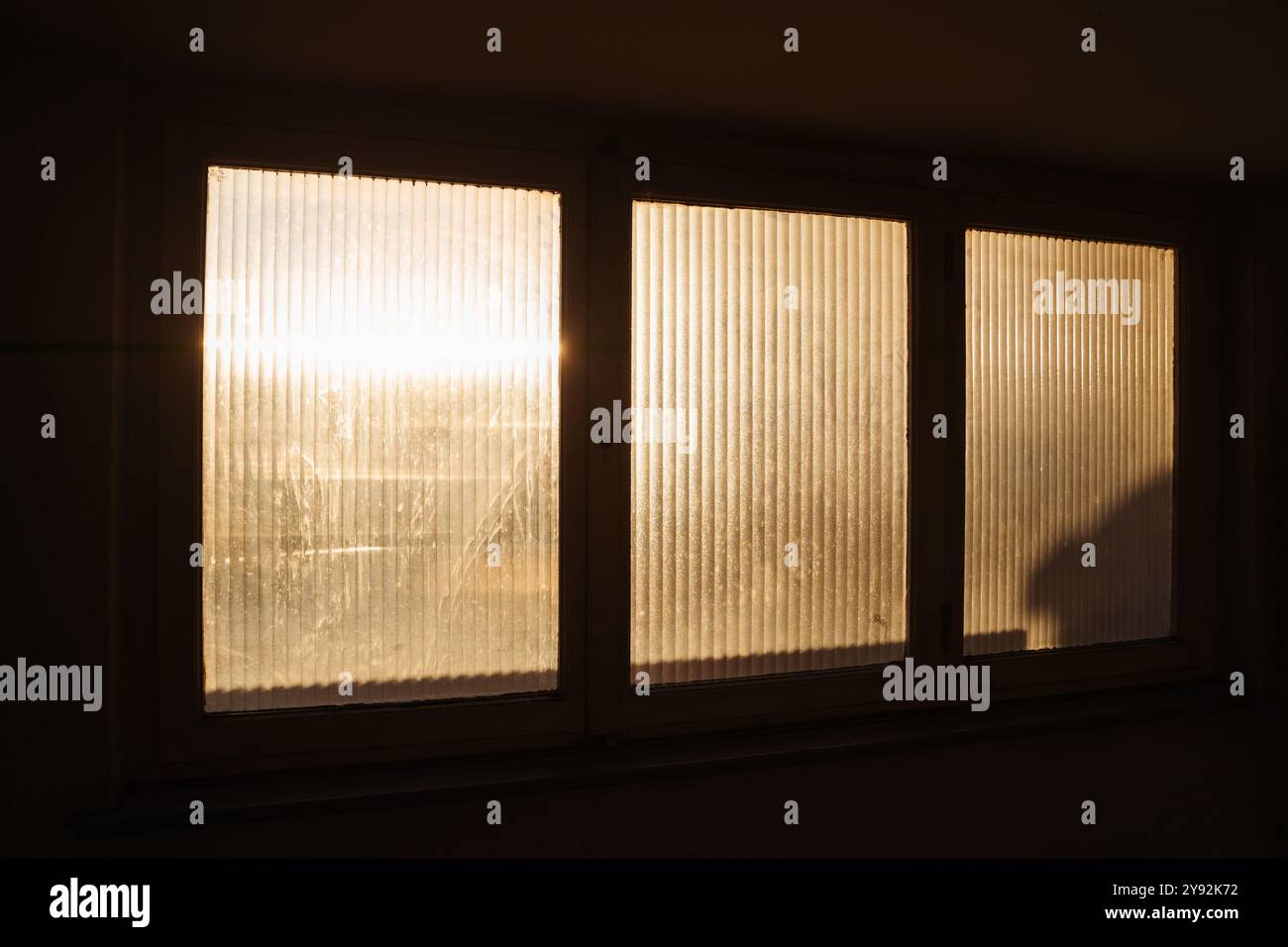 Warm morning sunlight filters through a frosted window, casting soft ...