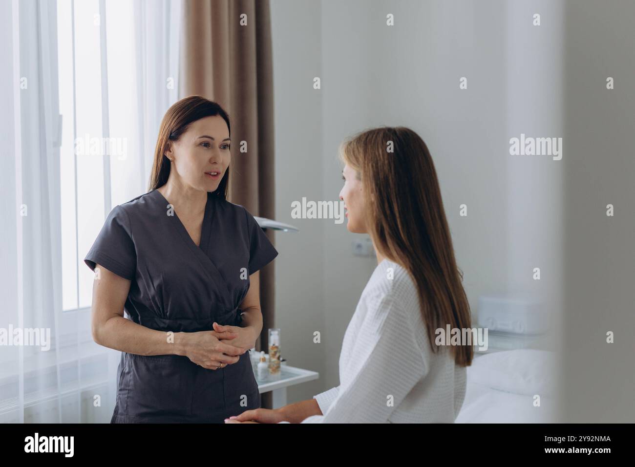 Consultation in cosmetology clinic. Female beauty doctor talking with ...
