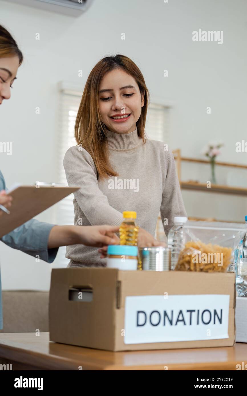 Woman Volunteering at Donation Center Sorting Food Items into Boxes for ...