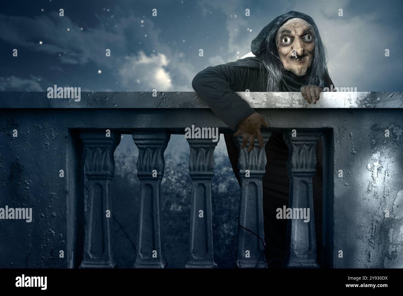 Old witch rising out behind balustrade with moonlight background. Scene ...
