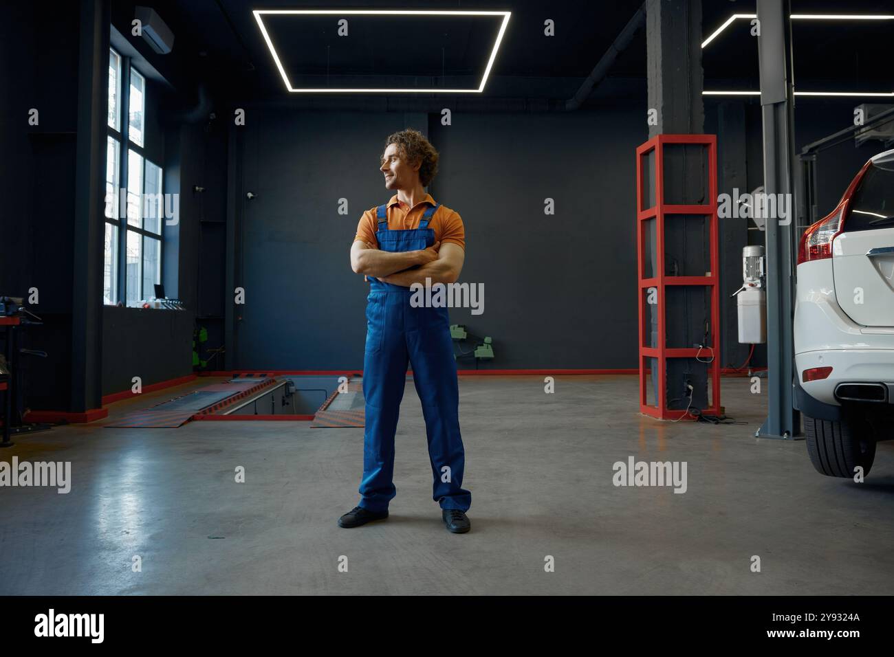 Full length portrait of man auto mechanic wearing uniform over garage ...