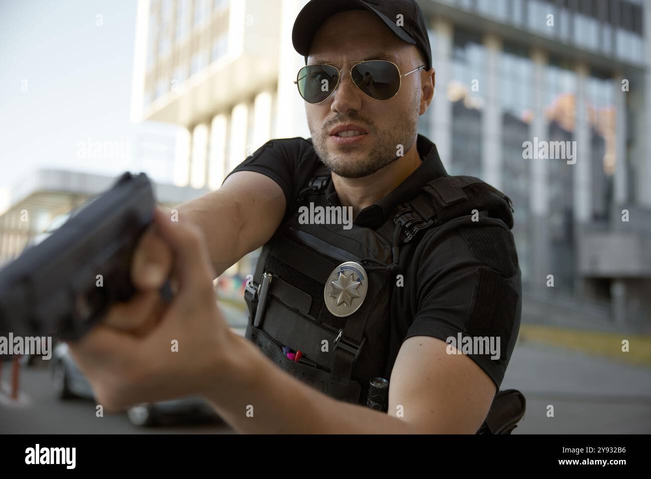 Portrait of man patrol police officer aiming with handgun at city ...