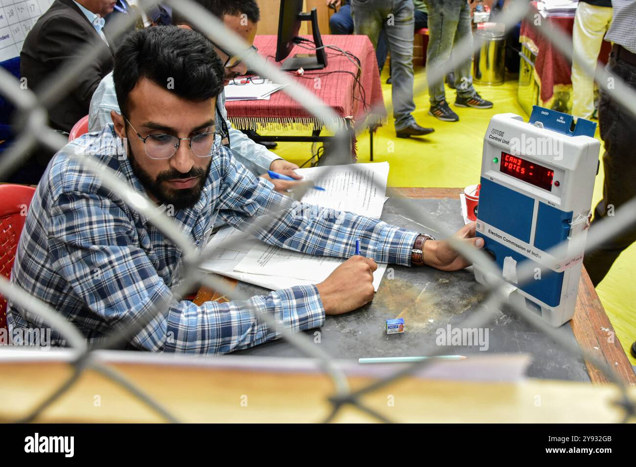 An electoral official counts votes from an Electronic Voting Machine ...
