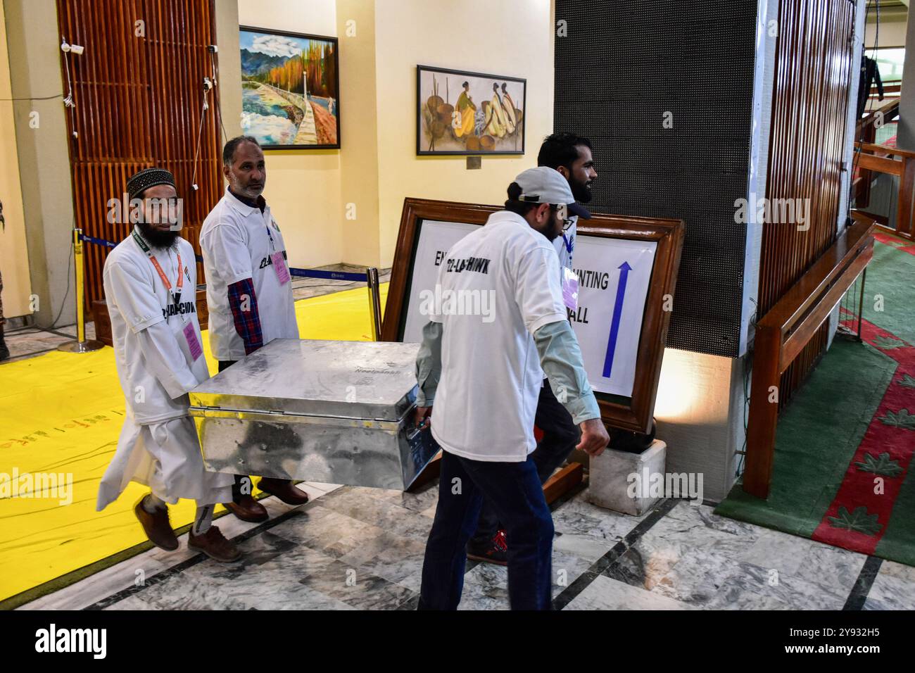Electoral officials carry a box full of Electronic Voting Machine (EVM ...
