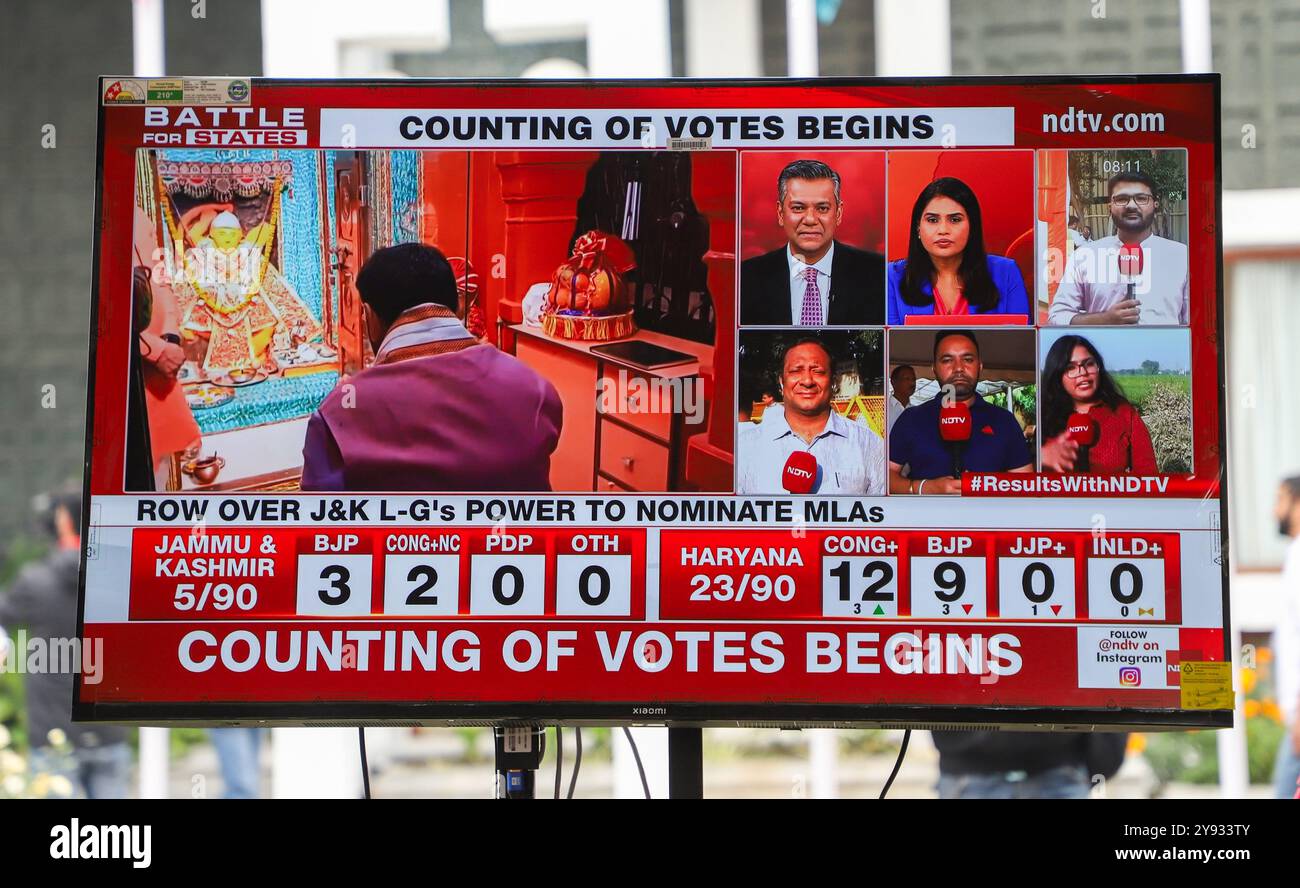 A Television screen shows poll results as election officials count ...