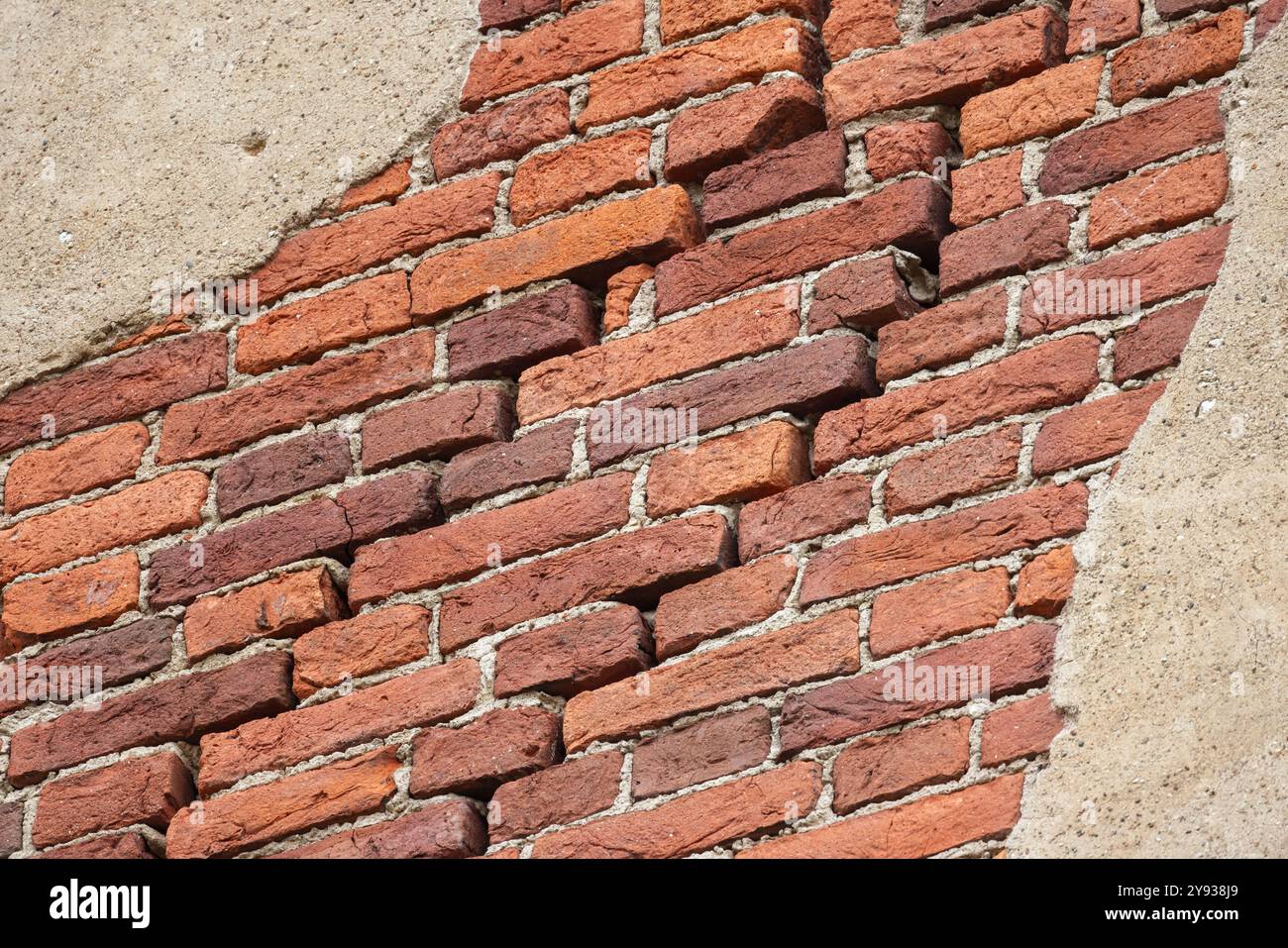 Old wall made of red bricks with yellow damaged stucco layer ...
