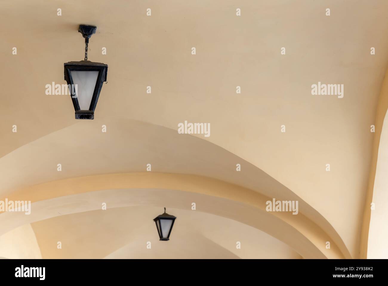 Vintage forged lamps are mounted at white arched passage ceiling Stock ...
