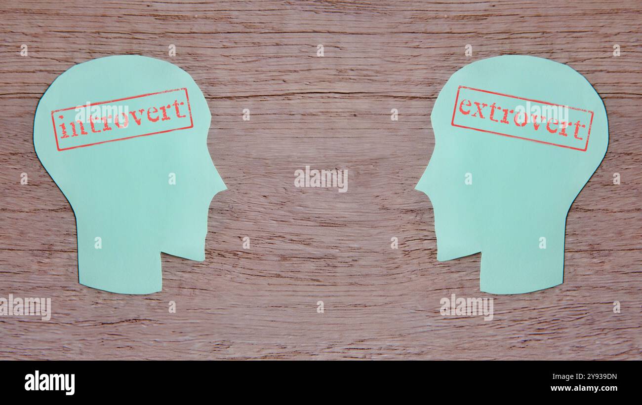 Two paper cutouts of human heads facing each other on a wooden ...