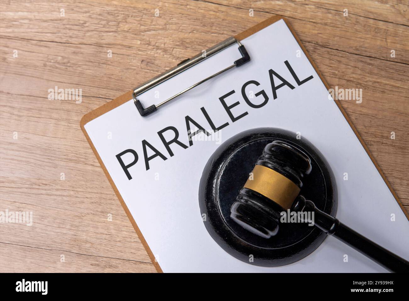 A clipboard with the word "PARALEGAL" and judge gavel. Law concept ...