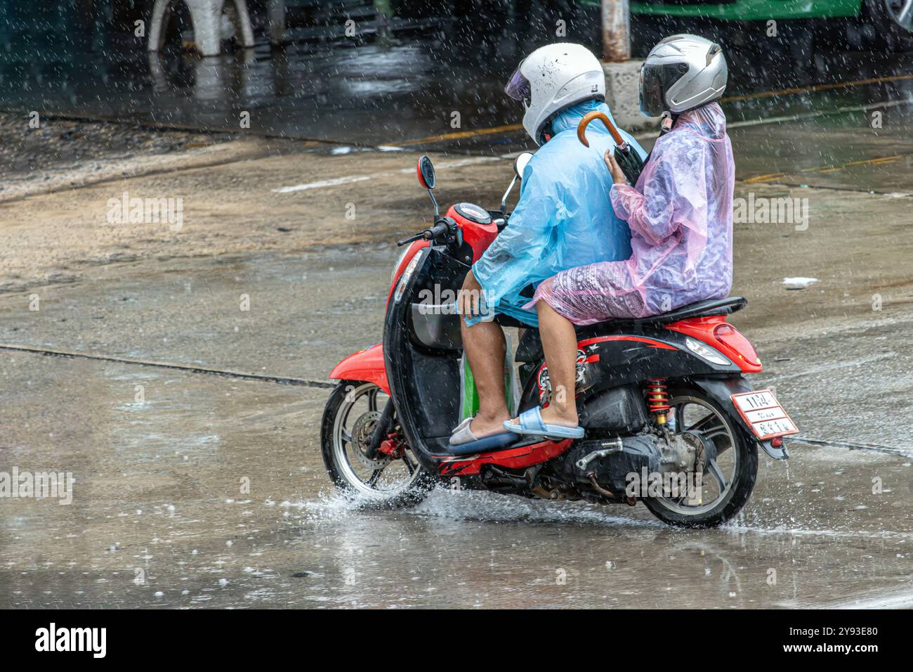 A moto-taxi drives with a passenger in the heavy rain, Bangkok ...