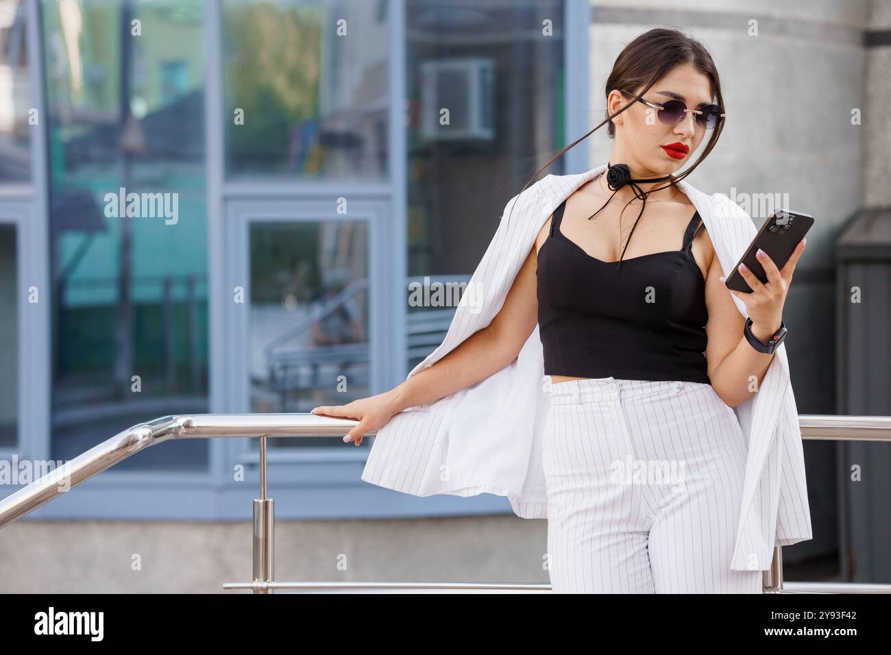 Stylish Young Woman in Chic Outfit Checking Phone in Modern Urban ...
