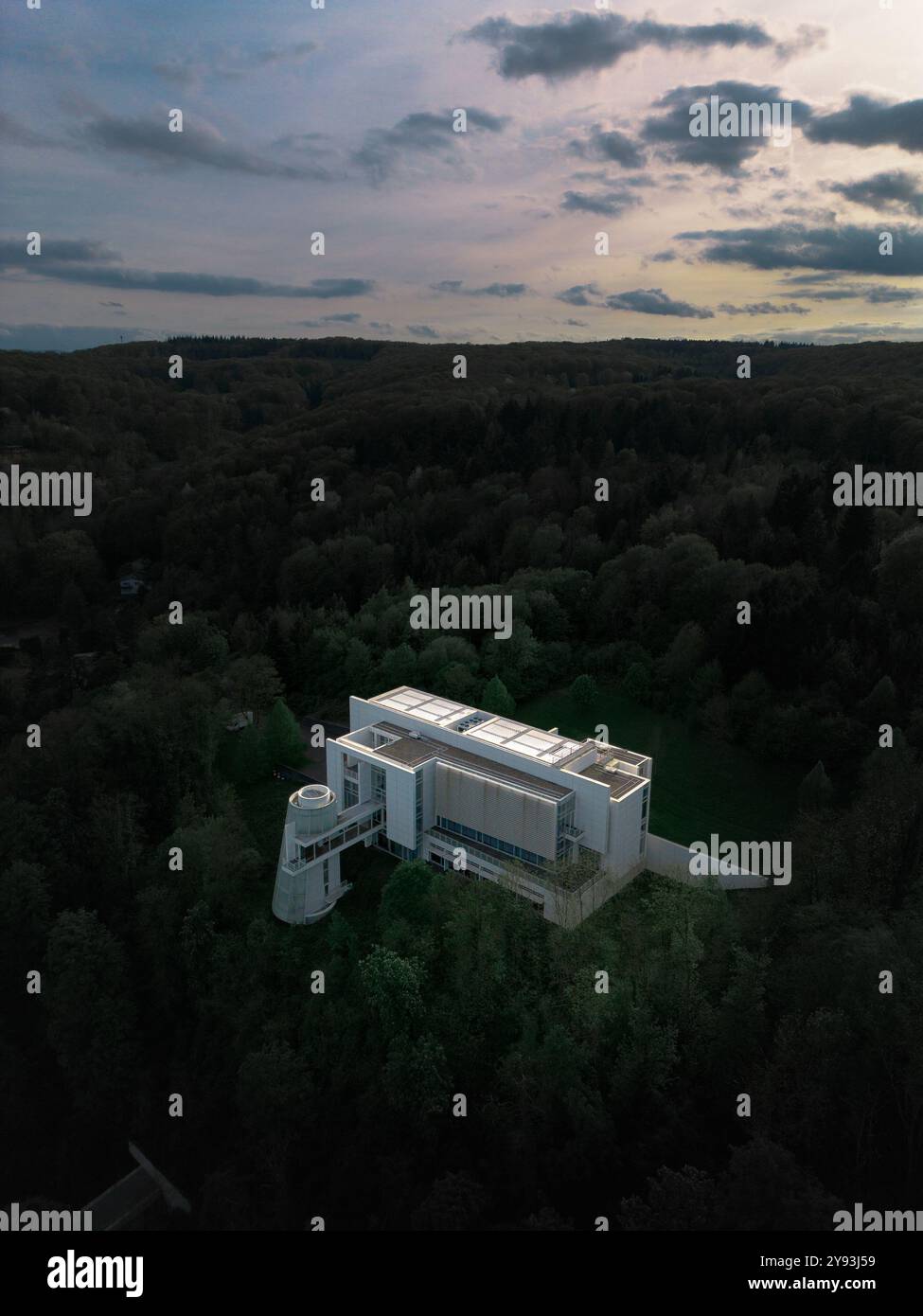 Aerial view of a modern architectural building nestled within a dense ...