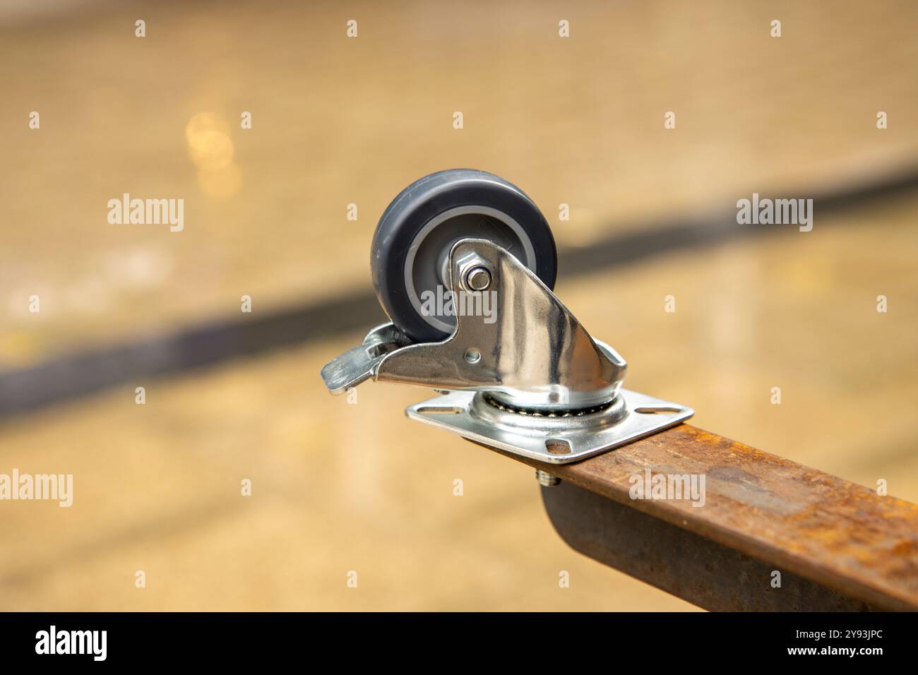A metal caster on a metal table leg Stock Photo - Alamy