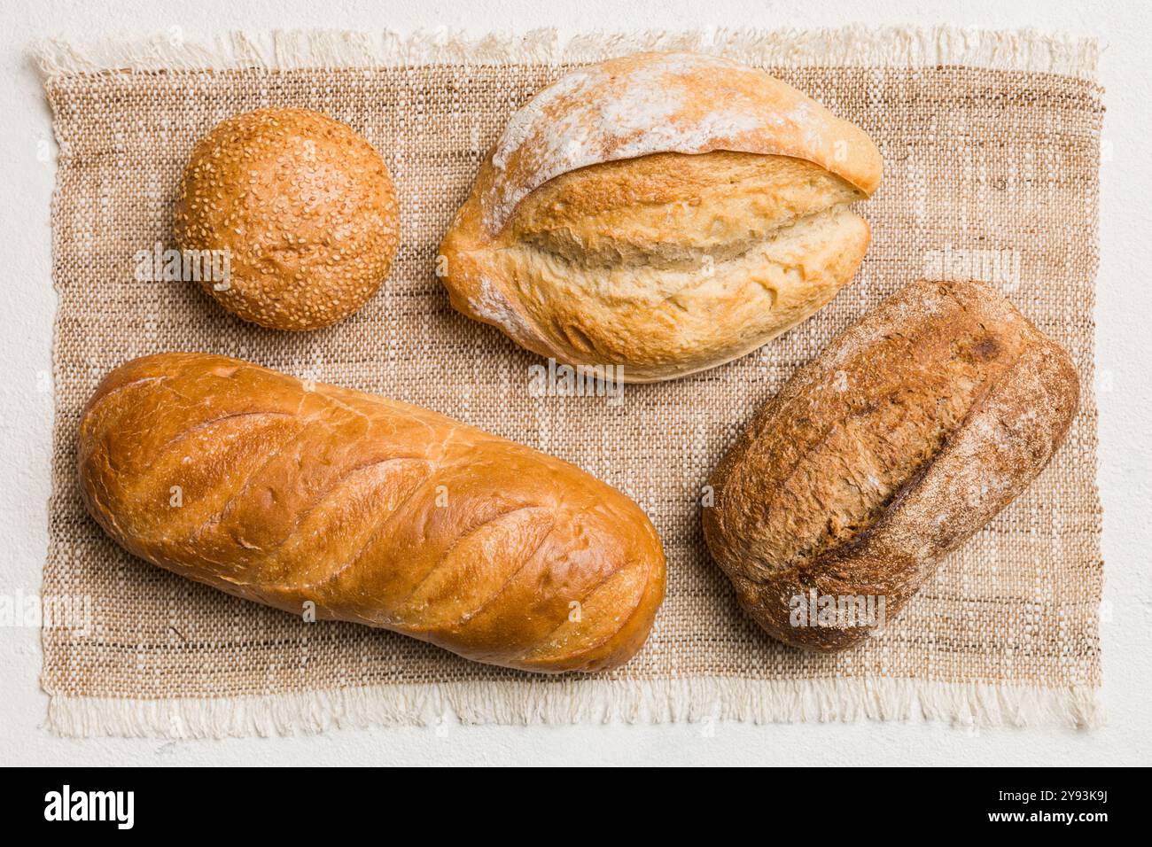 Assortment of freshly baked bread with napkin on rustic table top view ...