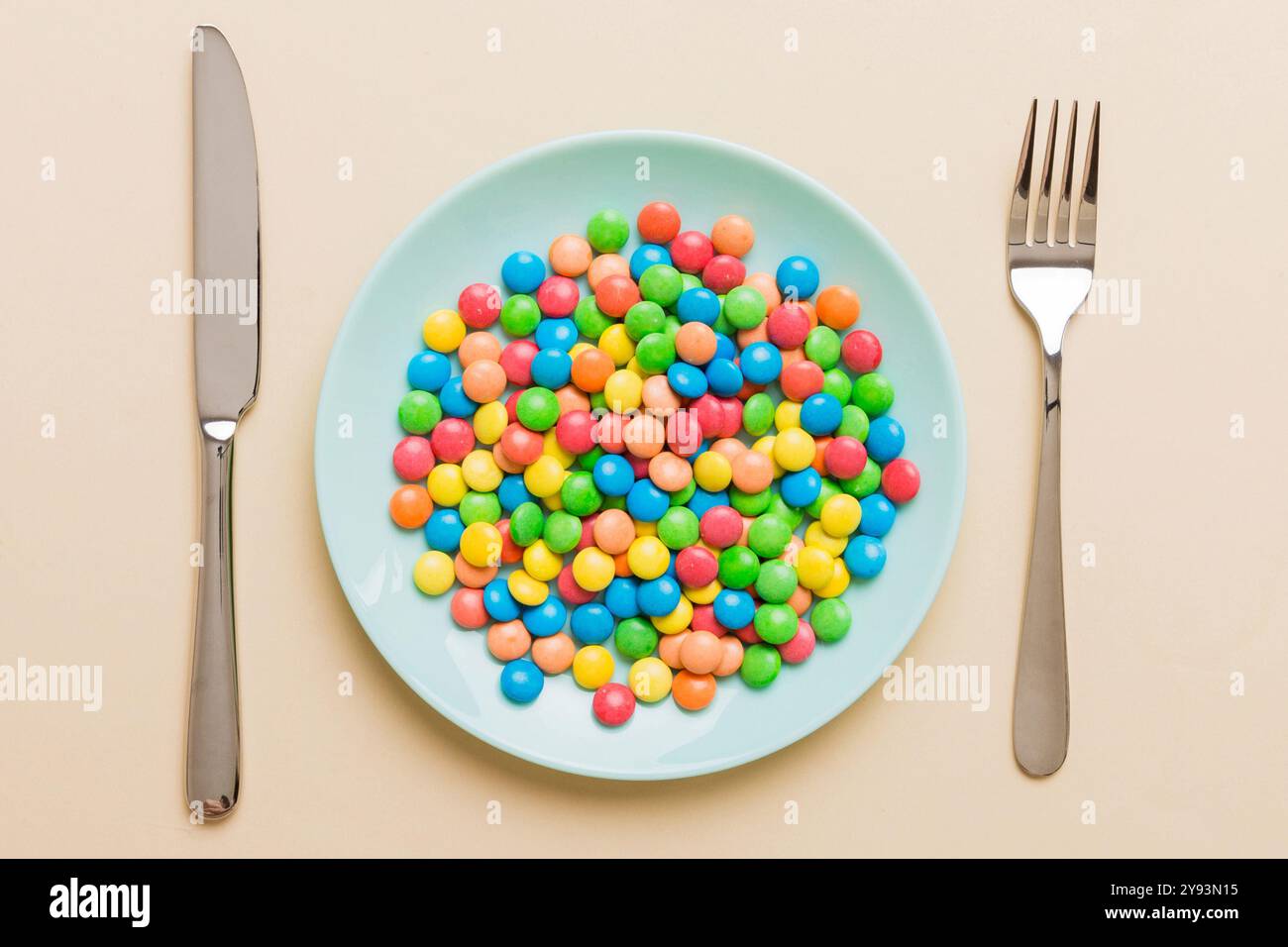 cutlery on table and sweet plate of candy. Health and obesity concept ...