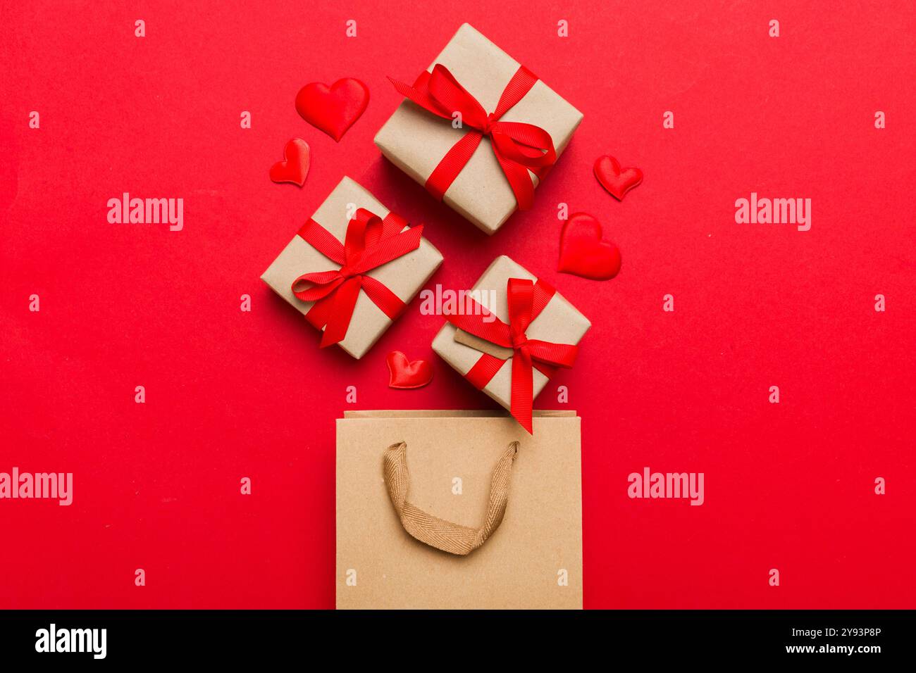 Gift boxes pop out from paper bag top view on colored background. bag ...