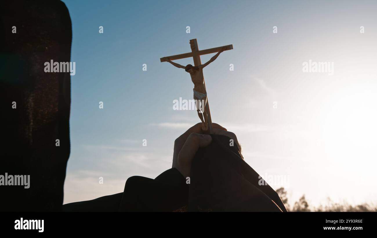 Monk raises crucifix to the sky Stock Photo - Alamy