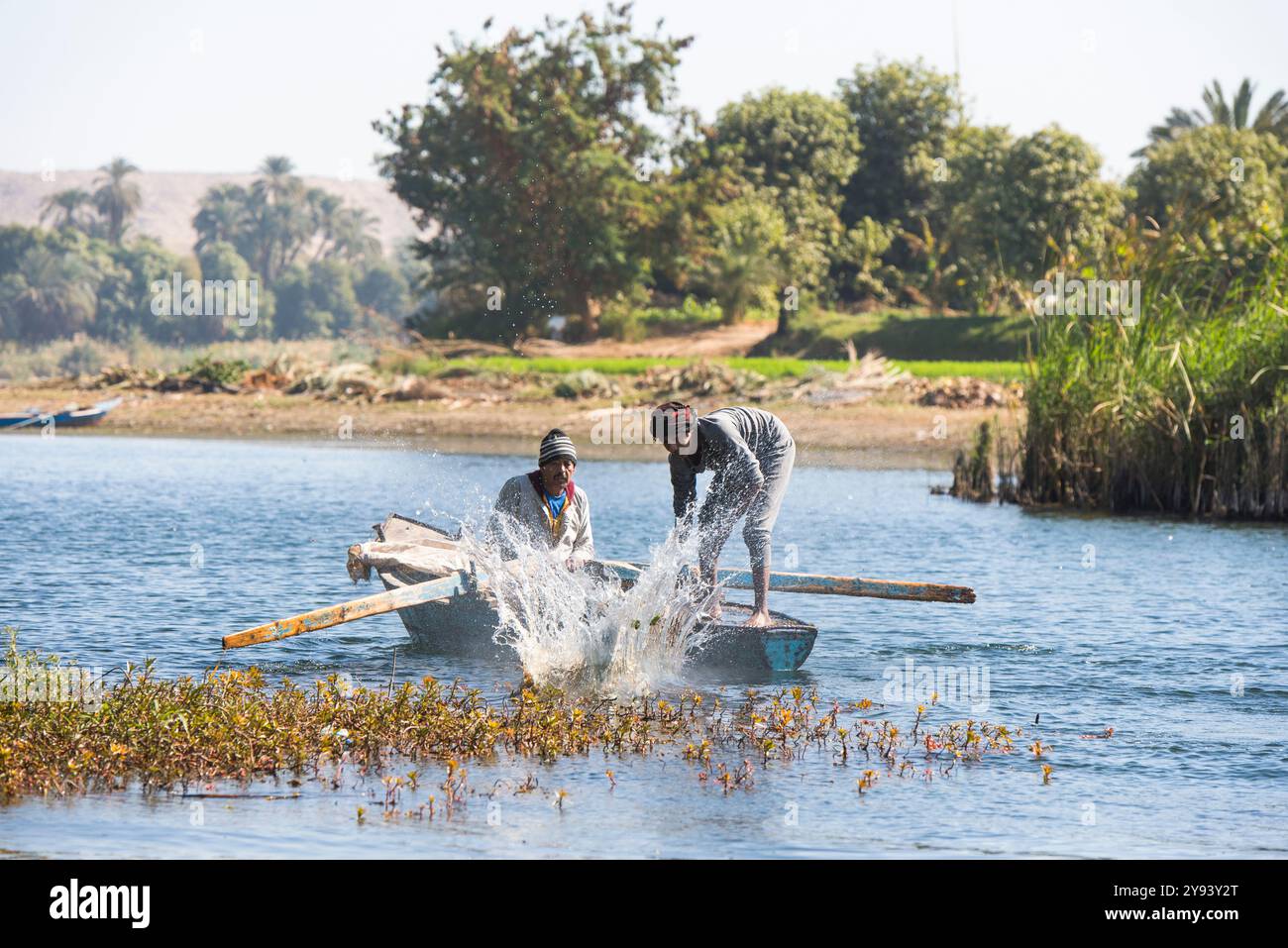 Net fishermen in rowing boat practising a technique of hitting the ...