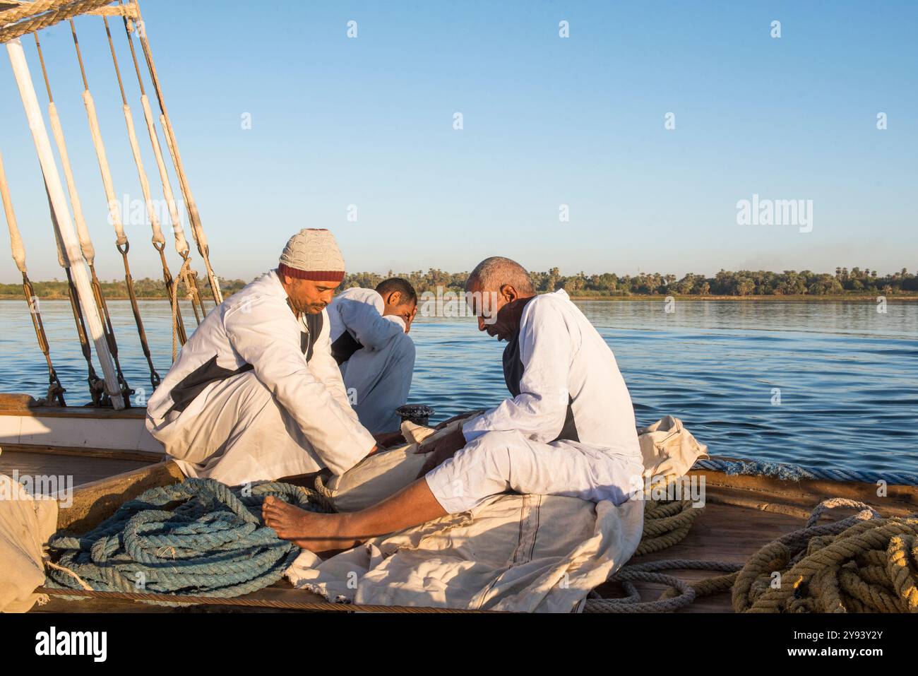 Members of the crew sitting at the prow of a dahabeah, passenger river ...