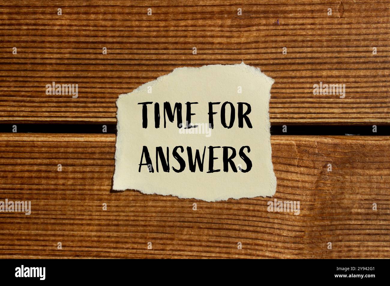 Time for answers message written on ripped torn paper with wooden ...