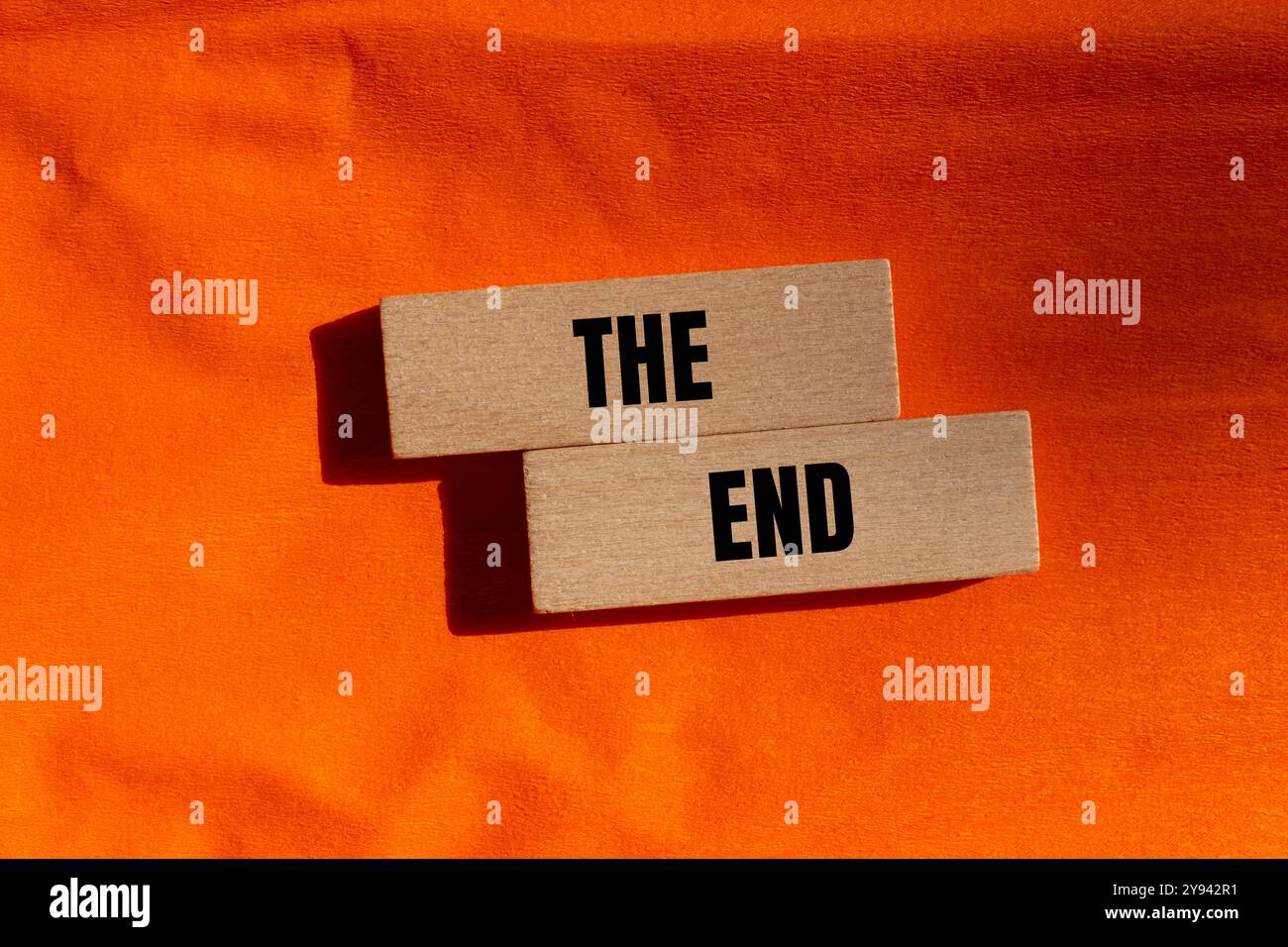 The end message written on wooden blocks with orange background ...