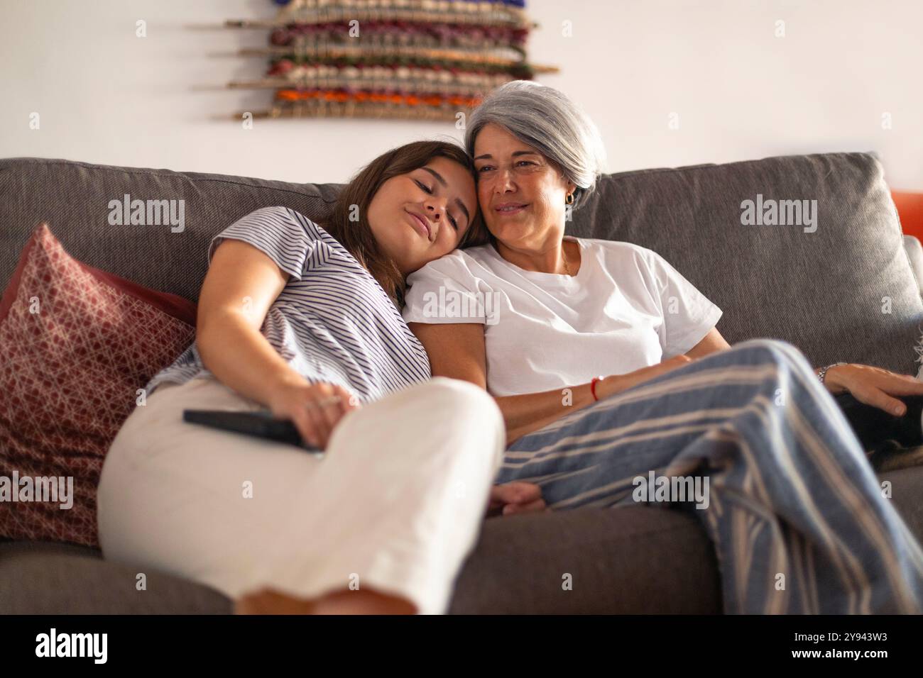 A serene image showing a young woman resting her head on her mother's ...