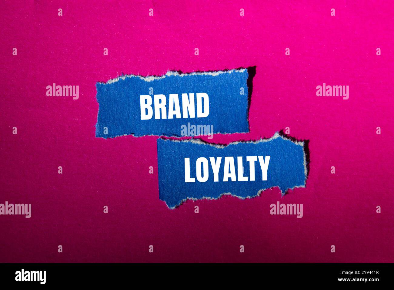 Brand loyalty message written on ripped torn blue paper pieces with ...