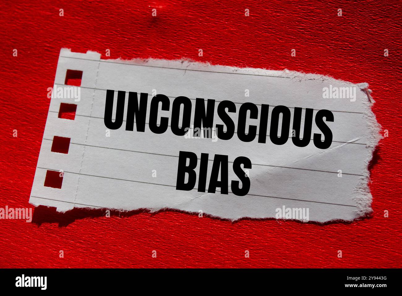Unconscious bias message written on ripped torn paper piece with red background. Conceptual ...