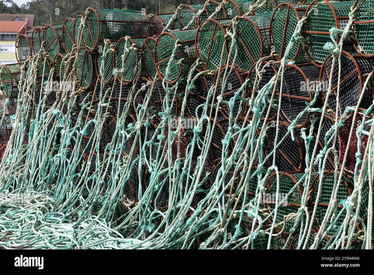 A detailed view of green fishing pots stacked together with a mass of ...