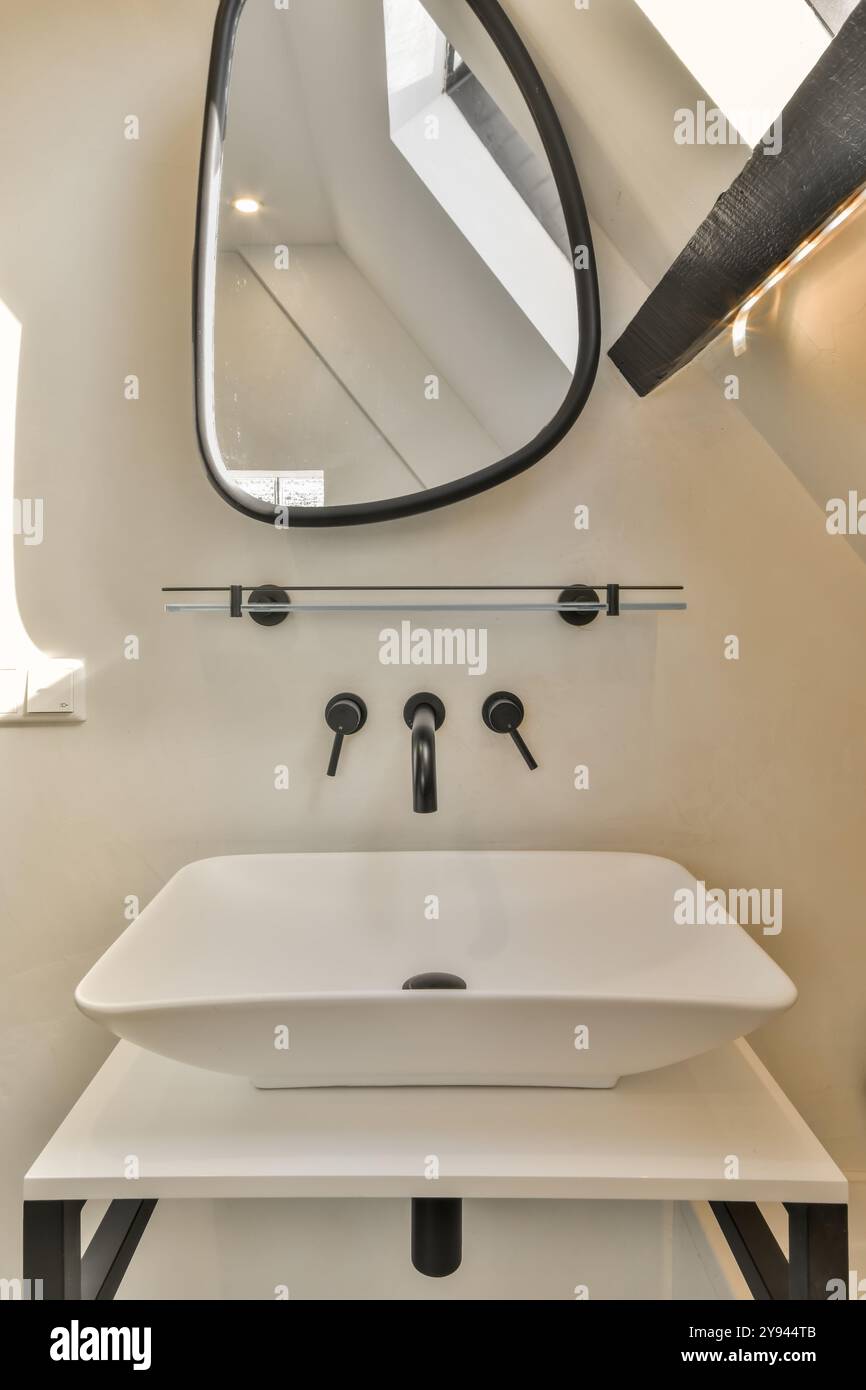 A contemporary bathroom featuring a geometric sink, a wall-mounted ...