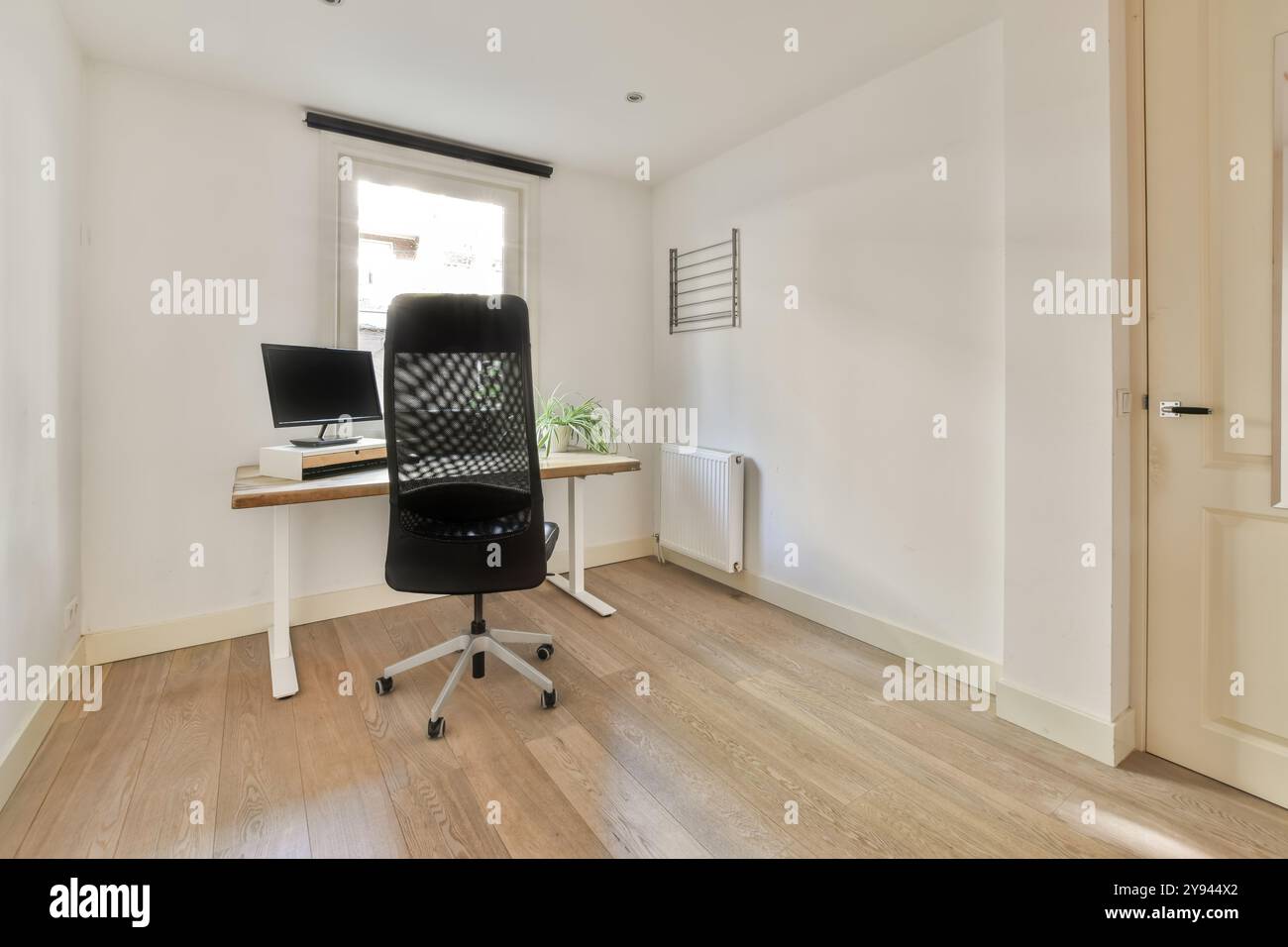 A minimalist modern home office setup featuring a wooden desk ...