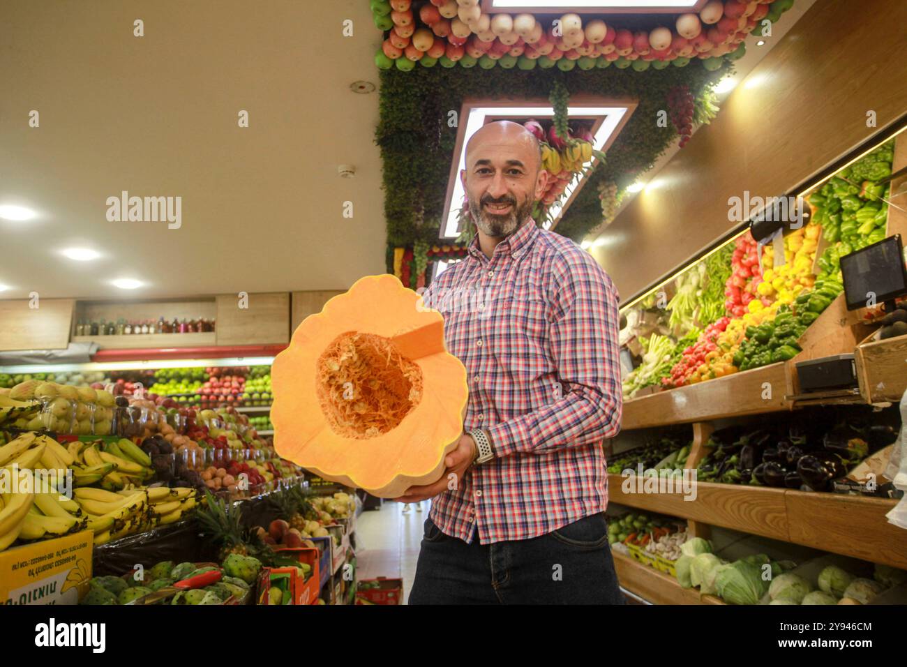 Palestinian Amir Shana, displays a pumpkin at his shop in the West Bank city of Nablus. Pumpkins ...