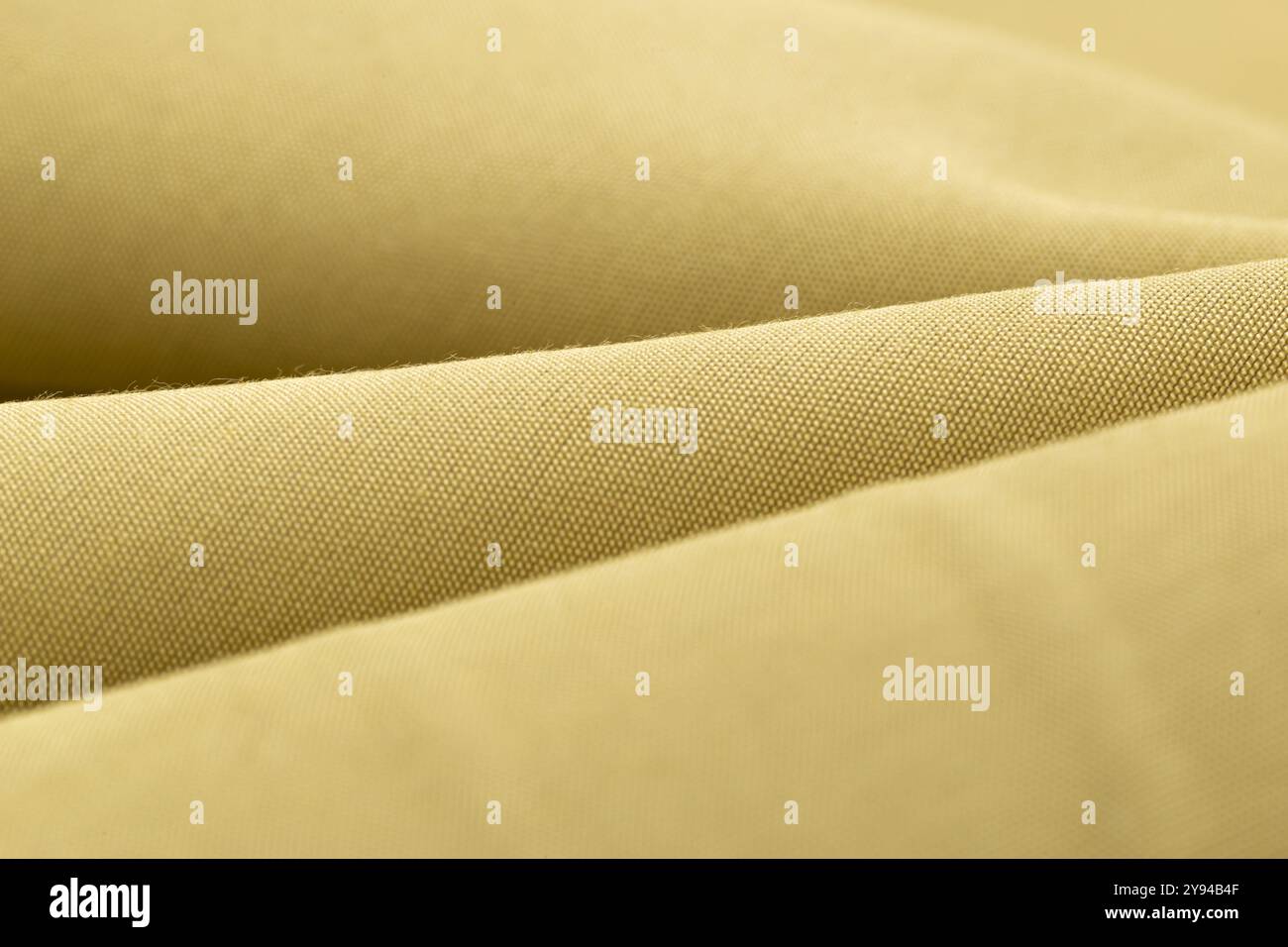 Soft yellow fabric close-up with subtle texture and gentle folds ...