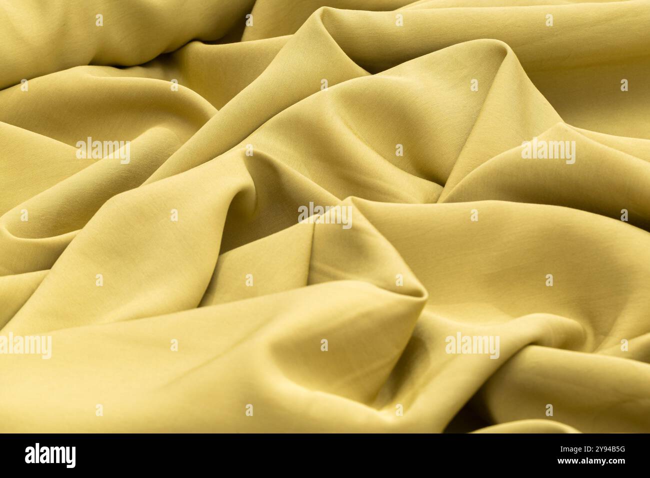 Soft yellow fabric with elegant folds, creating a smooth and luxurious ...