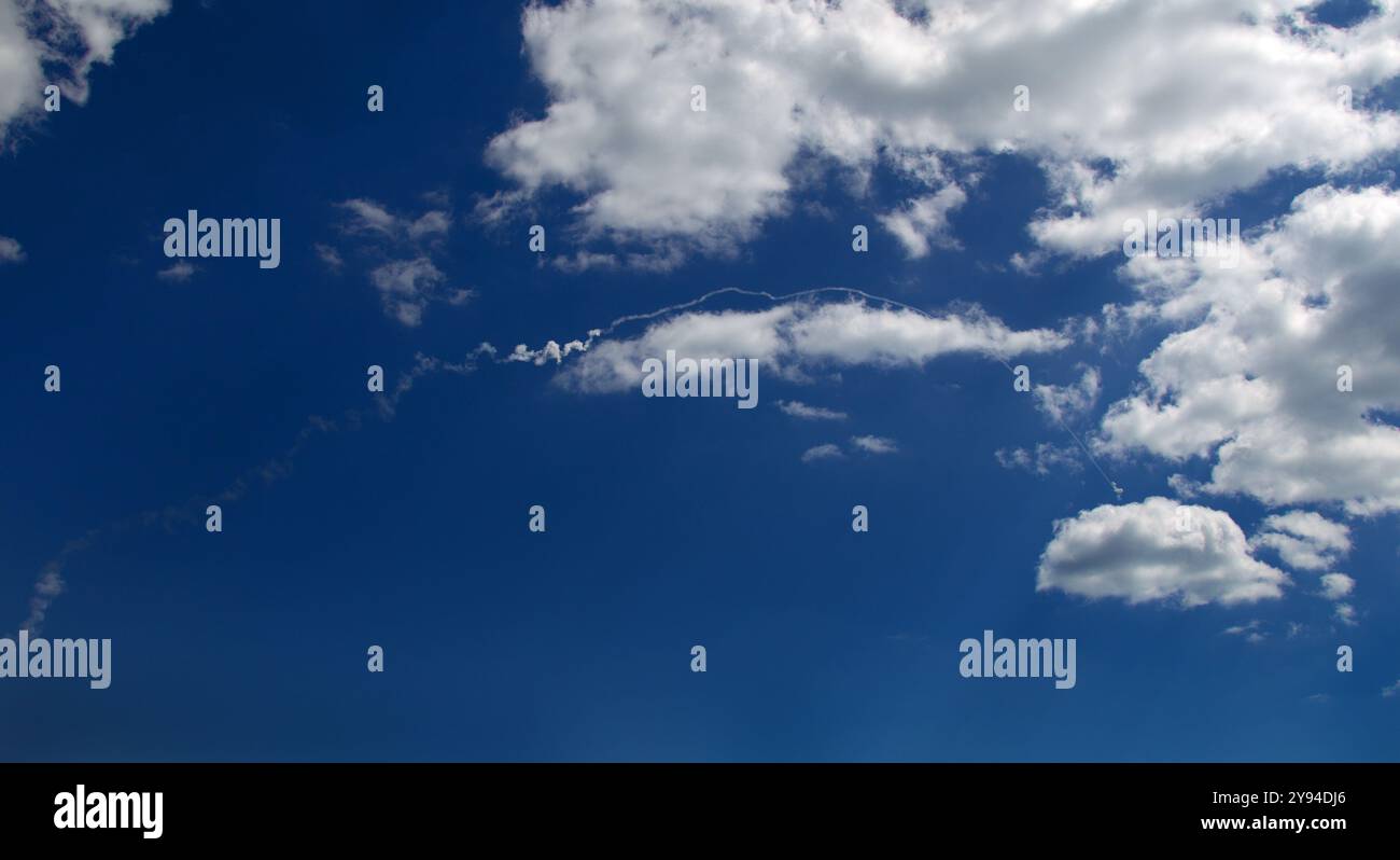 Blue Sky with White Tracer Missile Trail Over City Buildings During ...