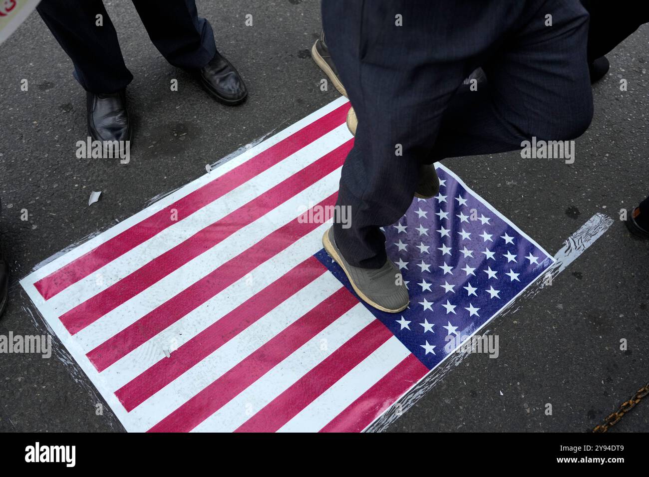 An Iranian demonstrator tramples a representation of the U.S. flag in ...