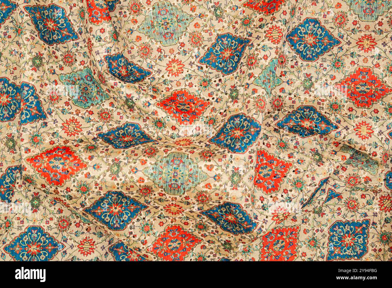 Persian floral textile with vibrant red, blue, and green patterns on a ...