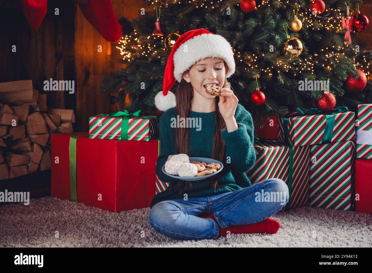 Full length photo of charming little girl sit floor eating snacks ...