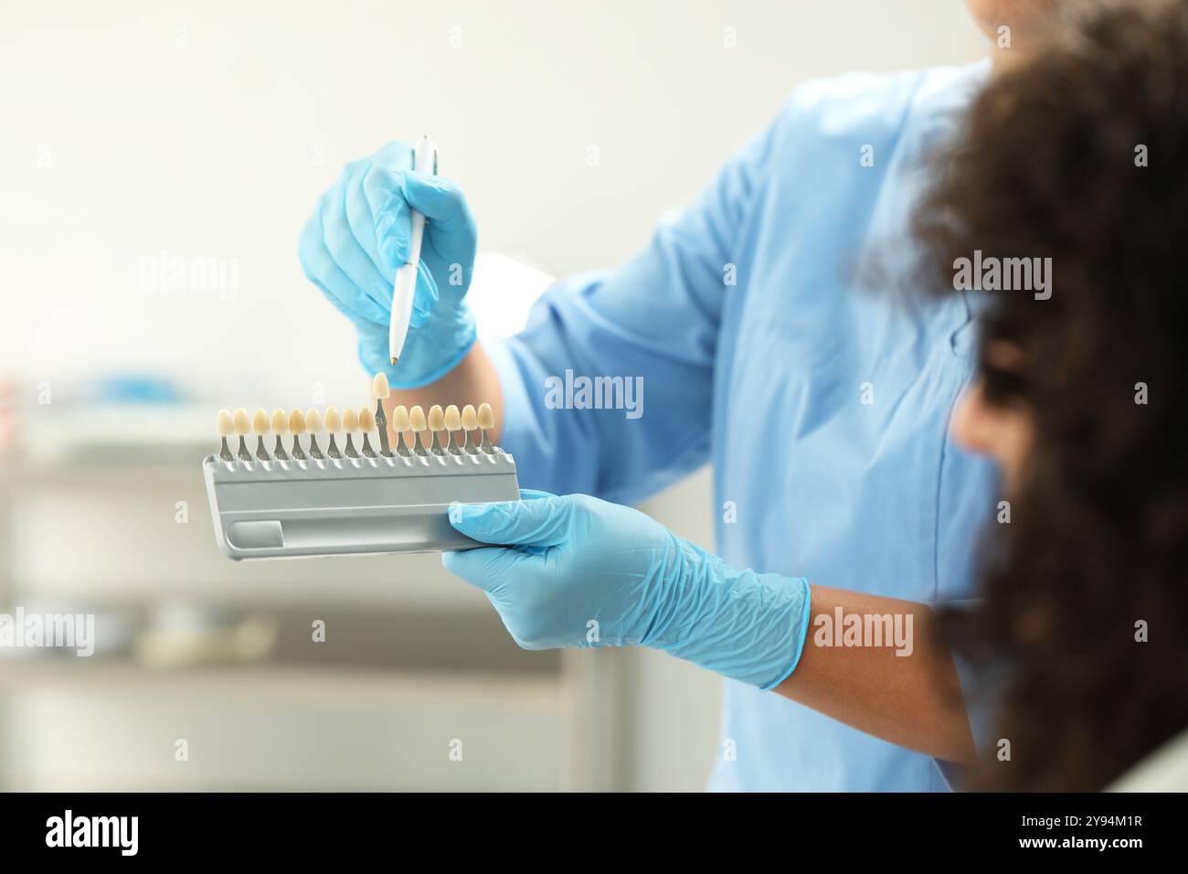 Doctor and patient choosing shade on teeth color palette in clinic ...