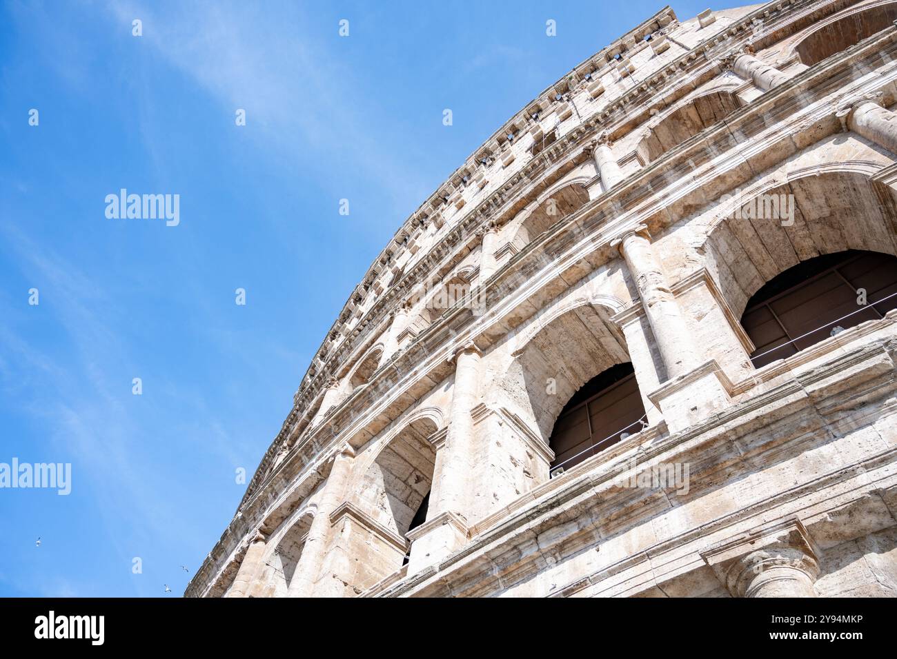 The Colosseum rises majestically against a clear blue sky, showcasing ...