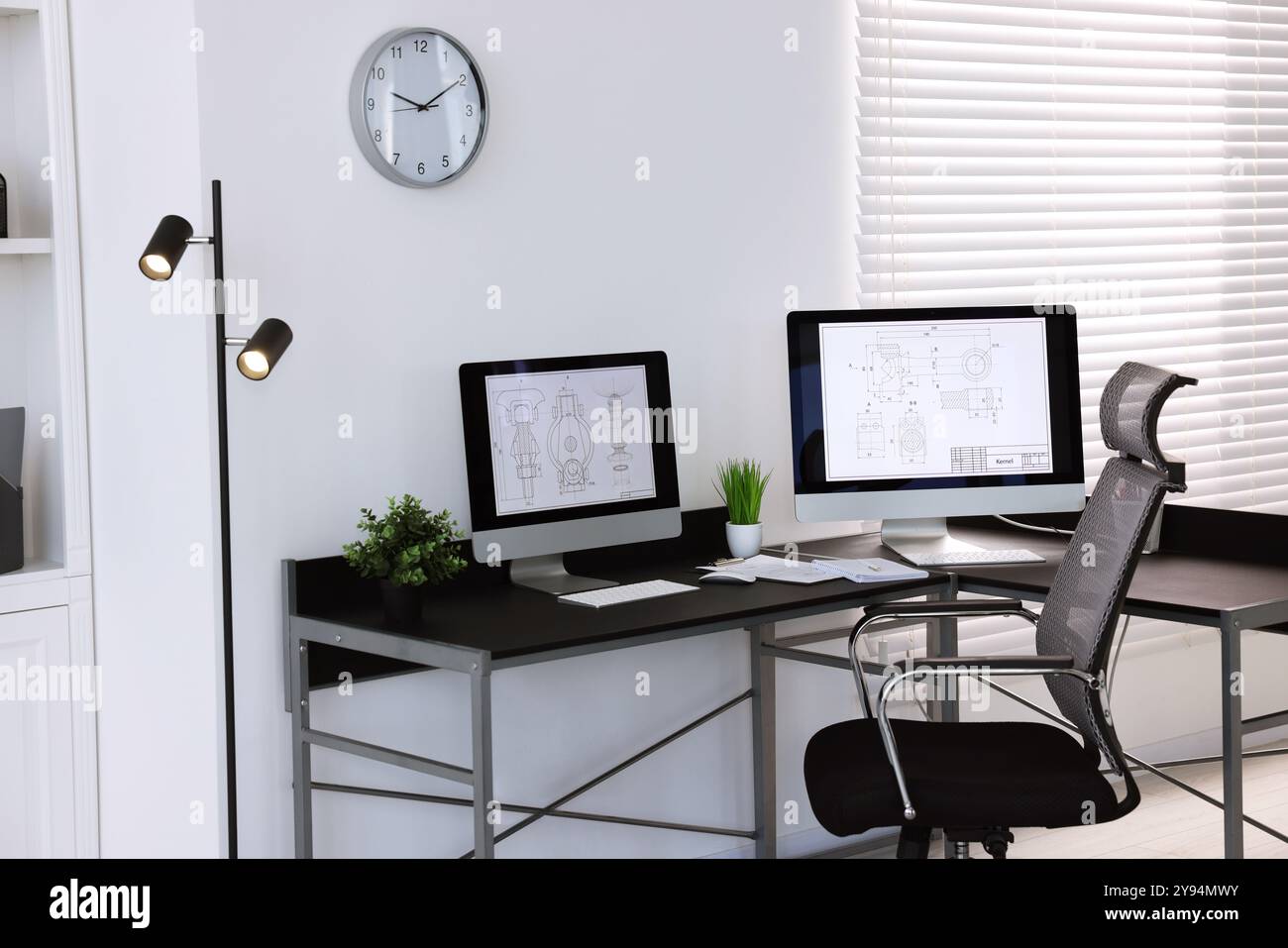 Modern computers with digital engineering drawing at table in office ...