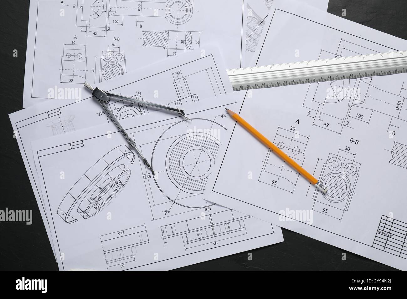 Different engineering drawings, pencil, ruler and divider on grey table ...