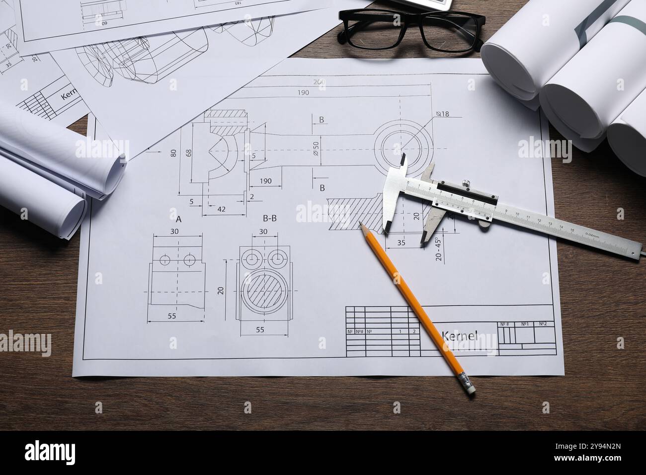 Different engineering drawings, glasses, vernier caliper and pencil on ...