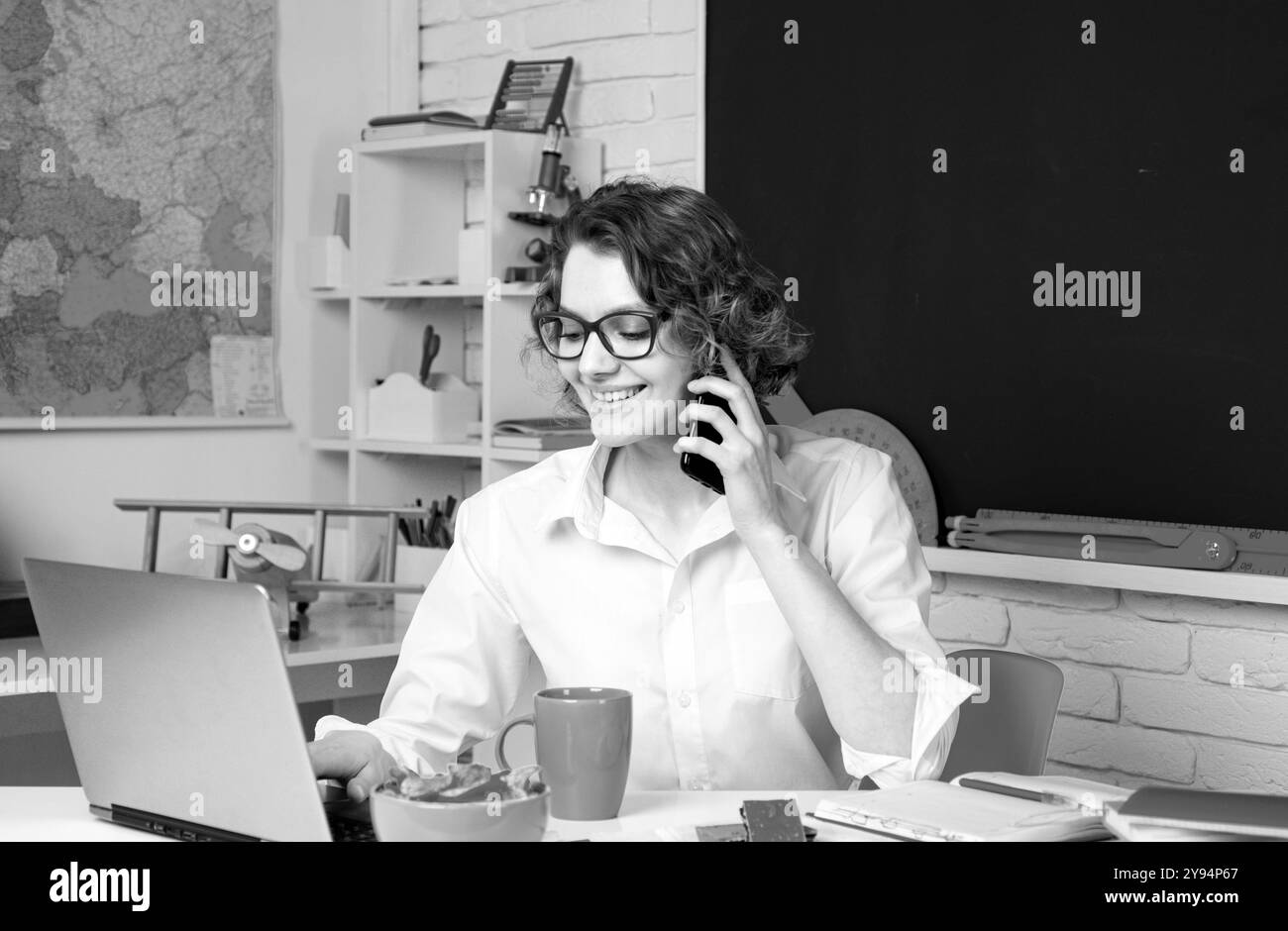 Shcool teacher with mobile phone use laptop in class on blackboard ...