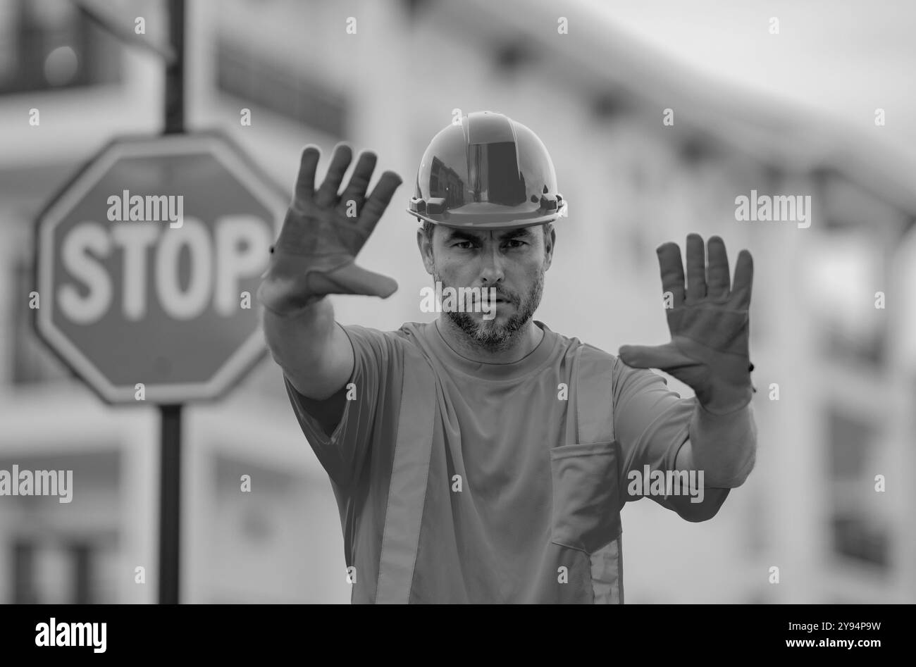 Worker builder in hard hat with stop road sign. Builder with stop ...